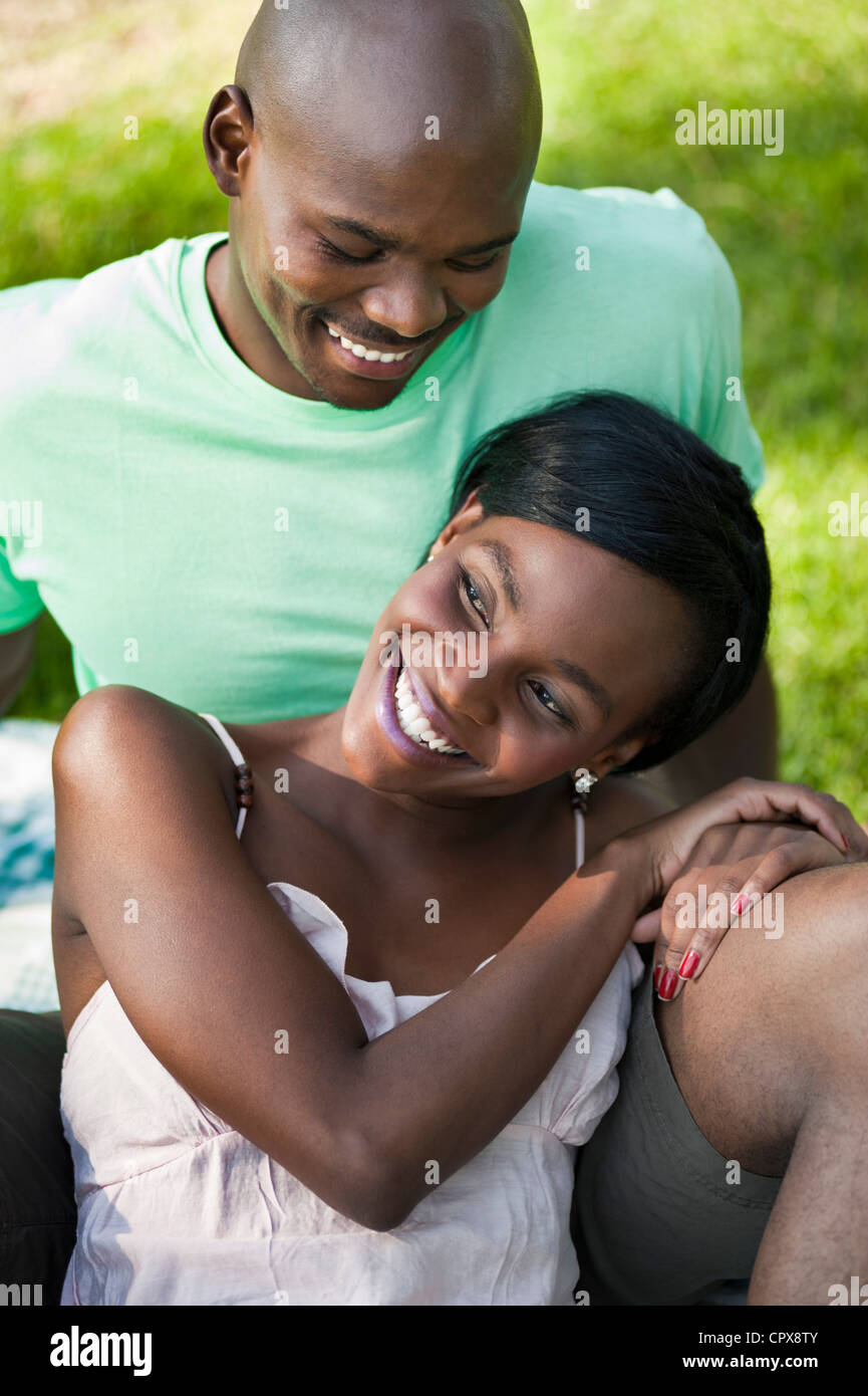 A young African couple sit together in a park Stock Photo - Alamy