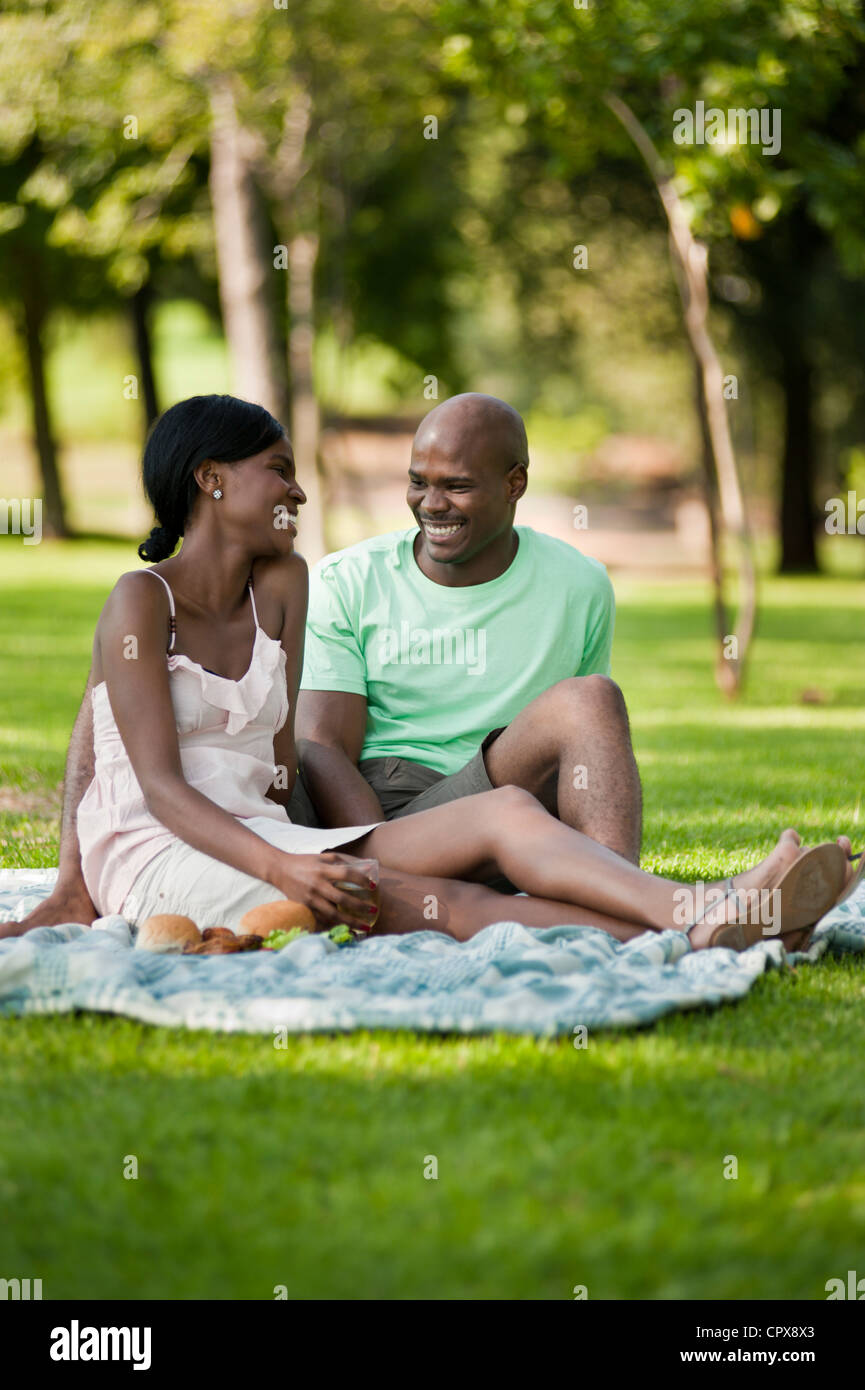 Young African couple having a picnic together in a park Stock Photo - Alamy
