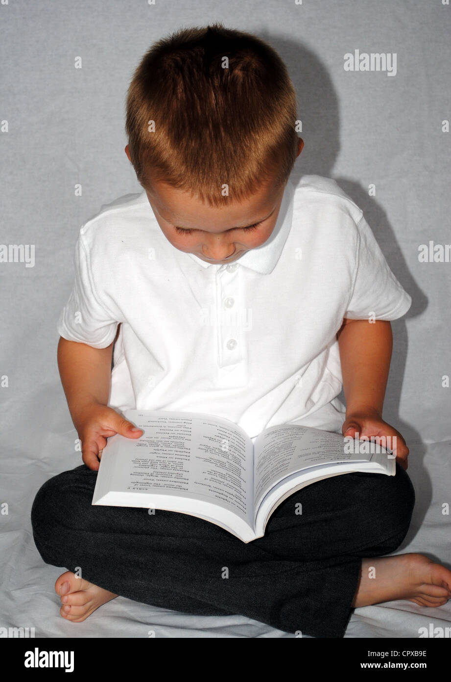 little boy is reading book Stock Photo - Alamy