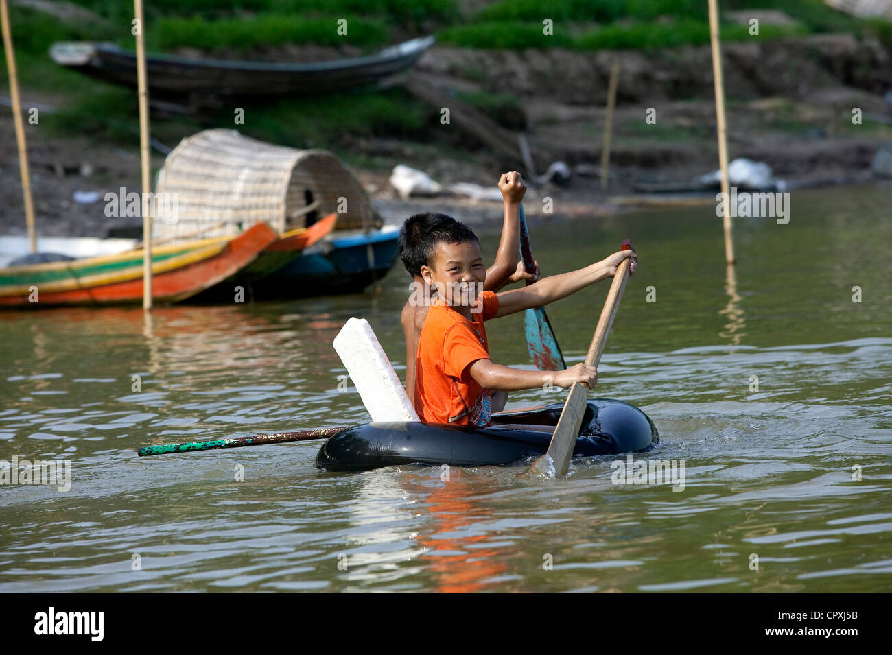 Laos, Luang Prabang province, alongside the Mekong, child playing with ...
