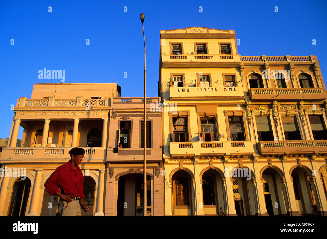 Cuba, Havana, person with a beret with the colored facades of the ...