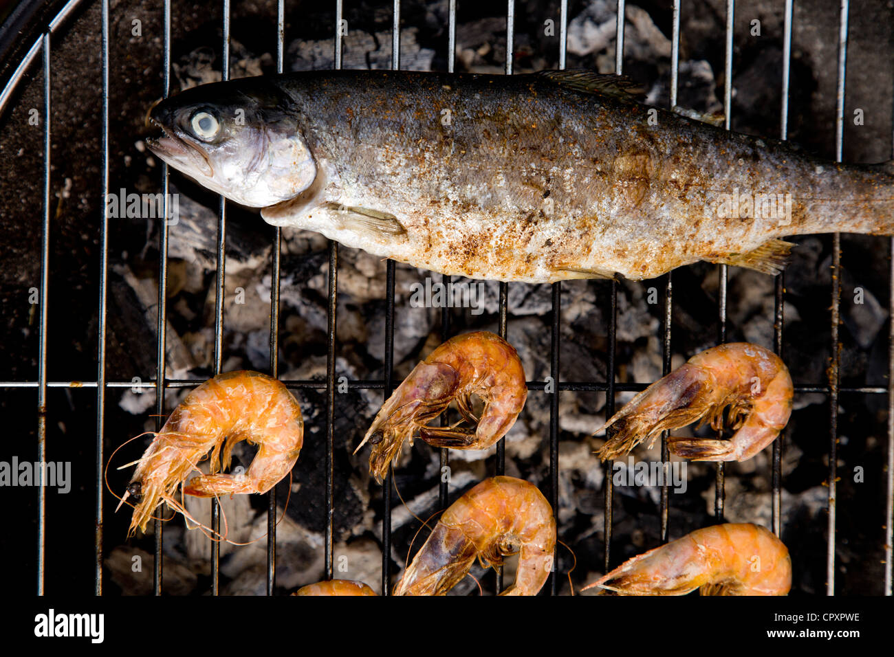 Seafood on grill. Fish and shrimps Stock Photo - Alamy