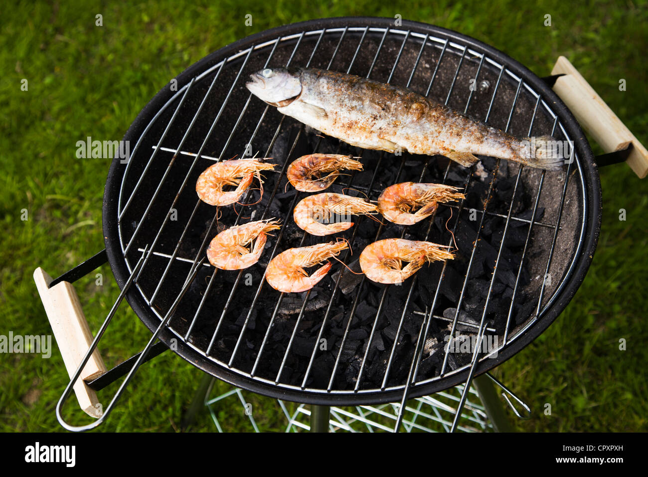 Seafood on grill. Fish and shrimps Stock Photo - Alamy