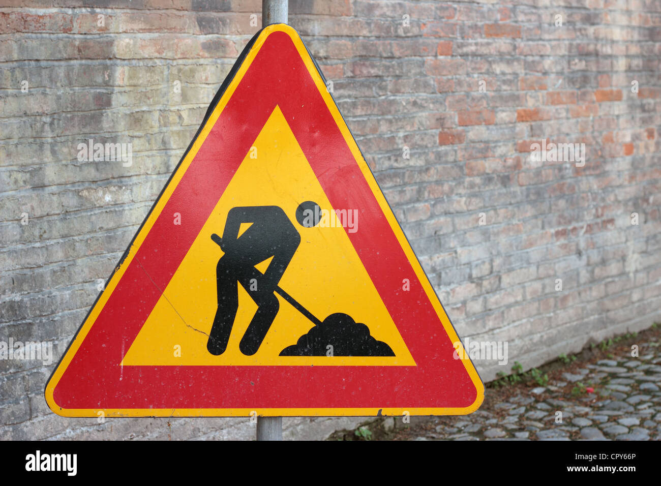 men at work, traffic sign on a brick wall Stock Photo - Alamy