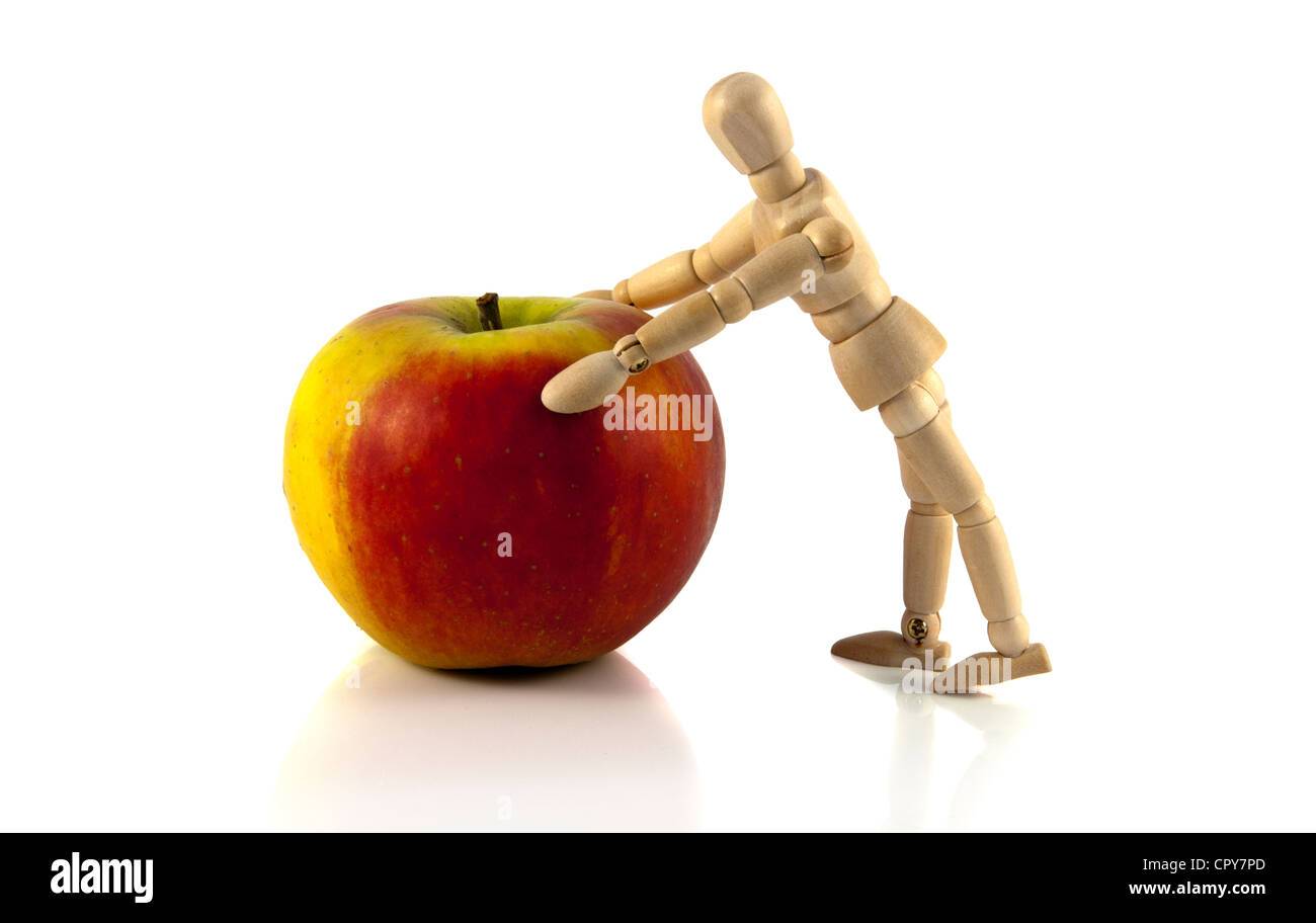 wooden male puppet pushing the apple Stock Photo - Alamy