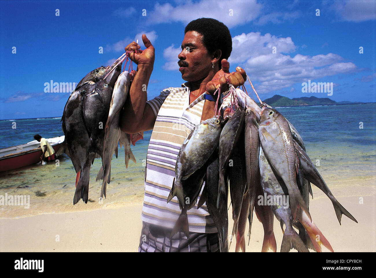 Seychelles, La Digue island, fishermen returning with fishes on their ...
