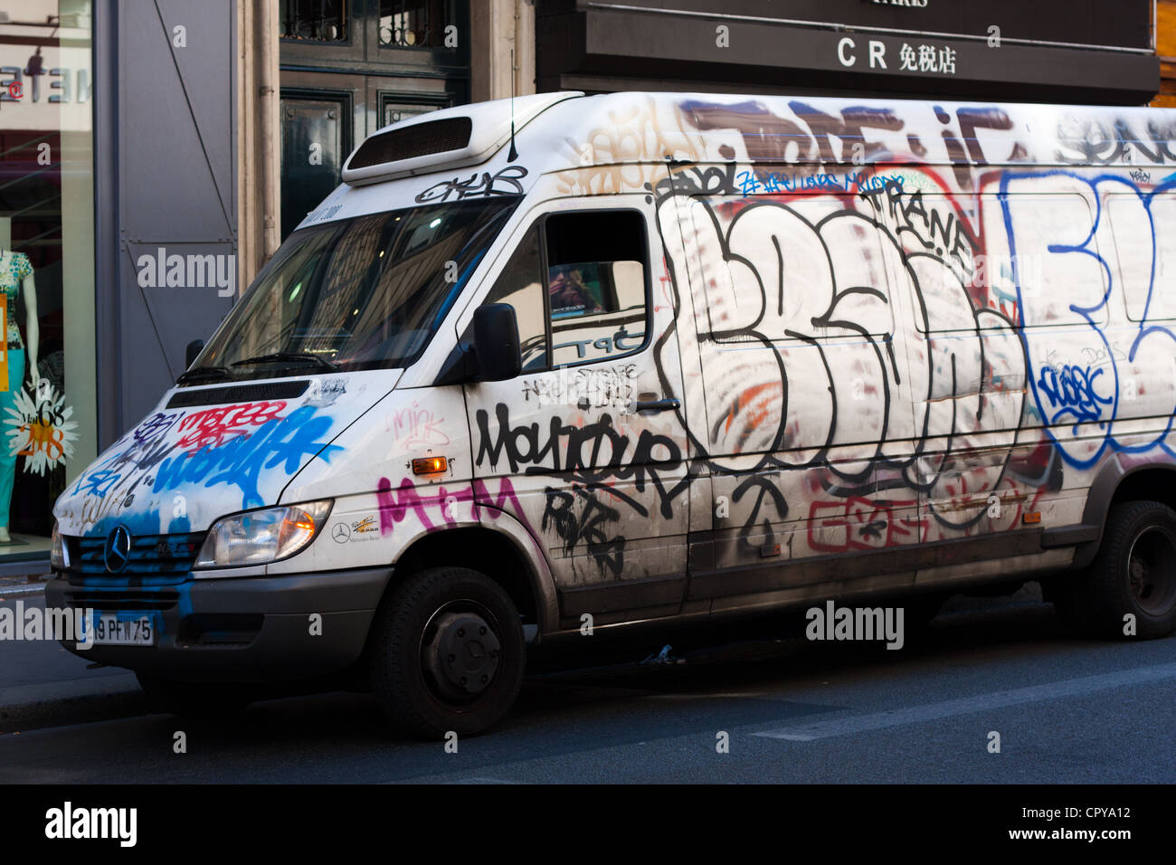 An urban scene with a white van sprayed painted with graffiti Stock ...