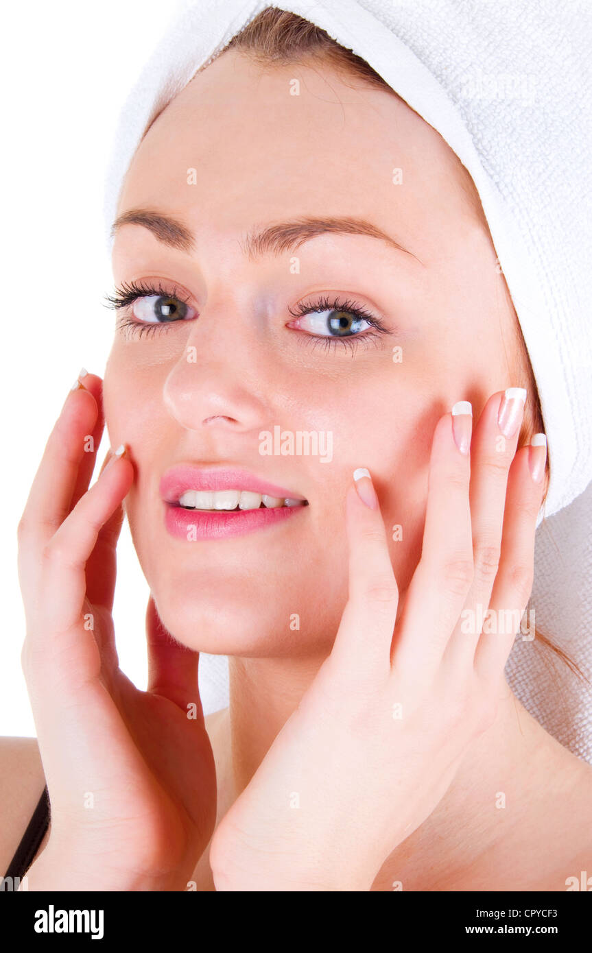 Young woman with smooth skin and white tower touch her face by finger ...
