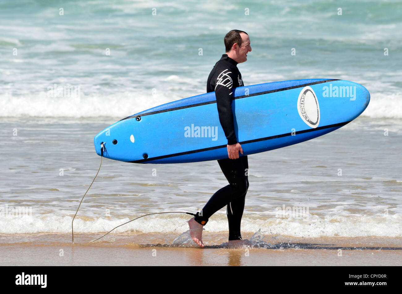 solitary surfer walking on beach carrying surf board Stock Photo - Alamy