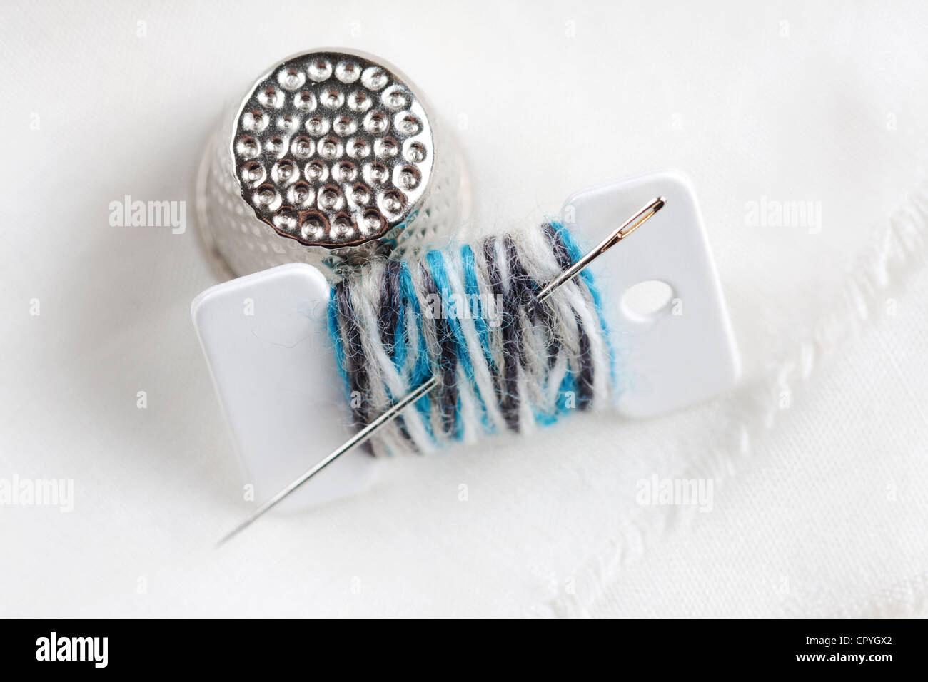 Needle, thread and thimble Stock Photo - Alamy
