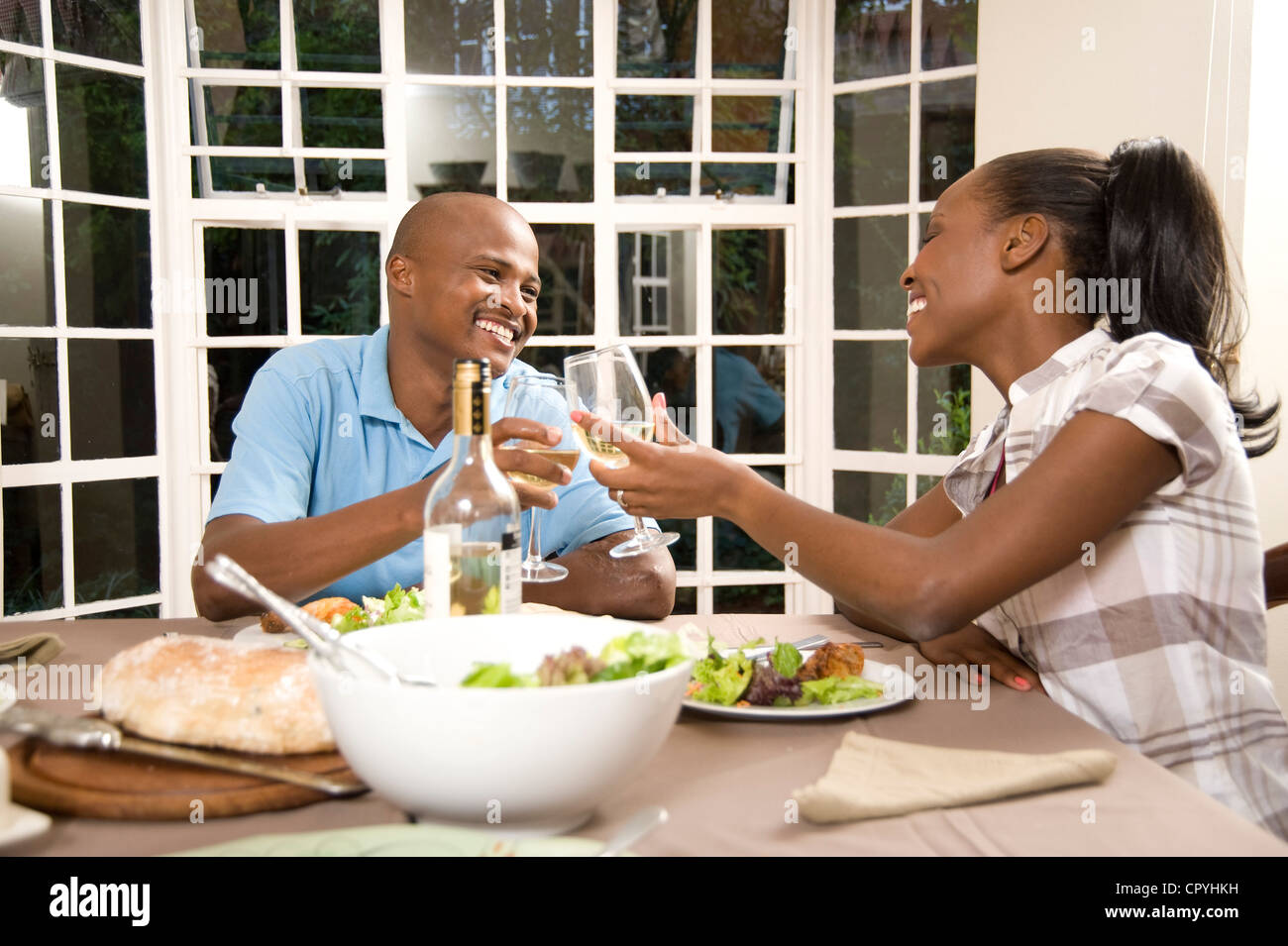 Young African couple enjoy a meal together at a dining room table Stock ...