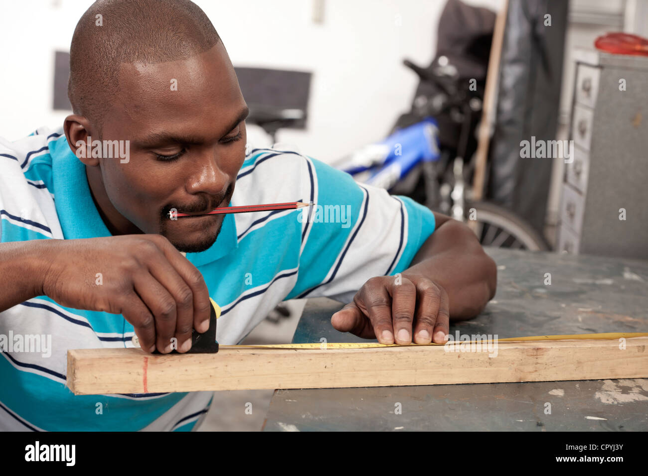 African man making measurements in a workshop Stock Photo - Alamy