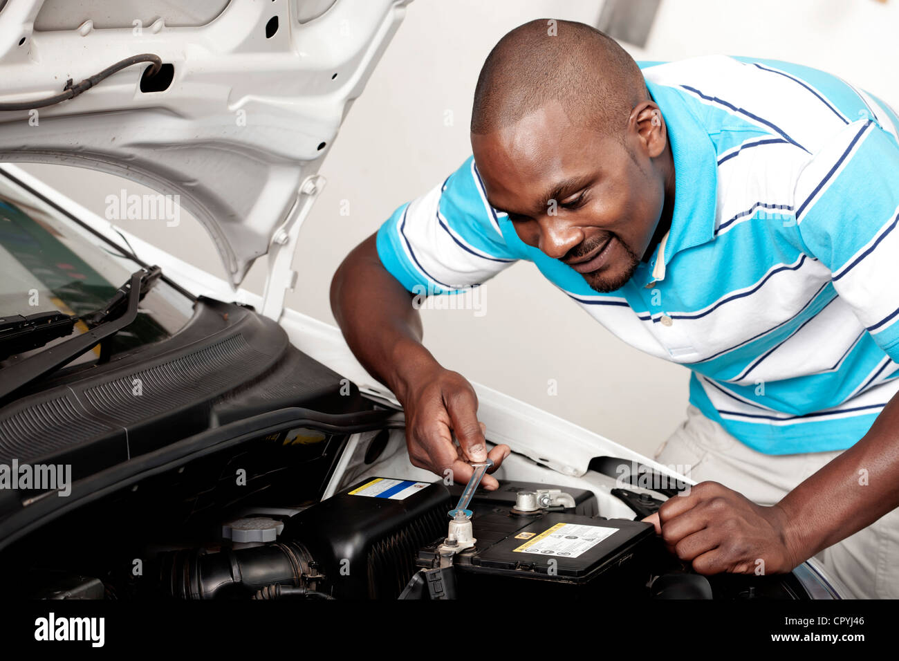 African man works on a car engine Stock Photo - Alamy