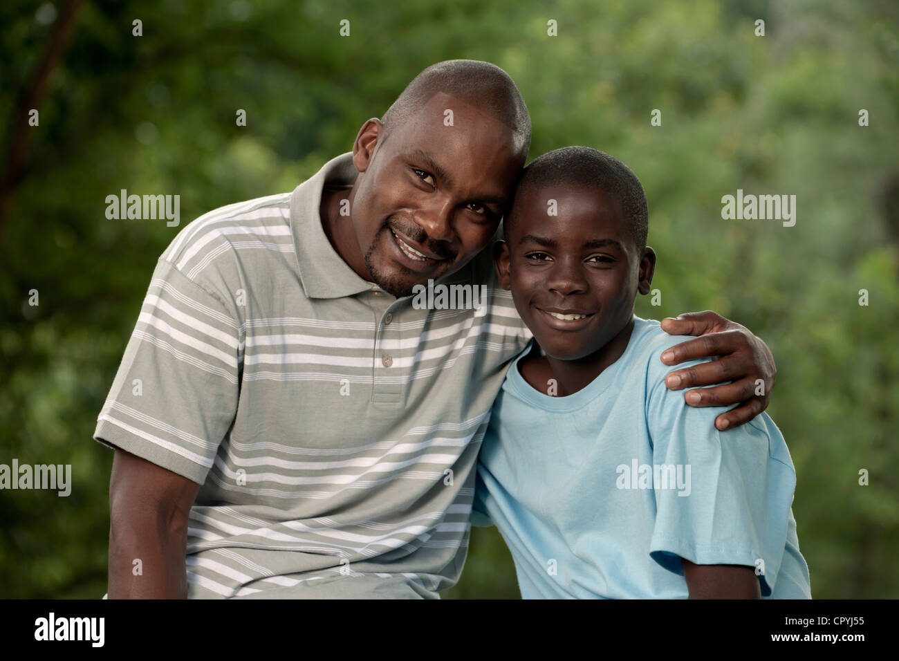 African father and son sitting outside in a garden Stock Photo - Alamy