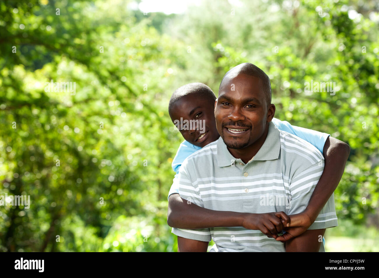 African father and son sitting outside in a garden Stock Photo - Alamy