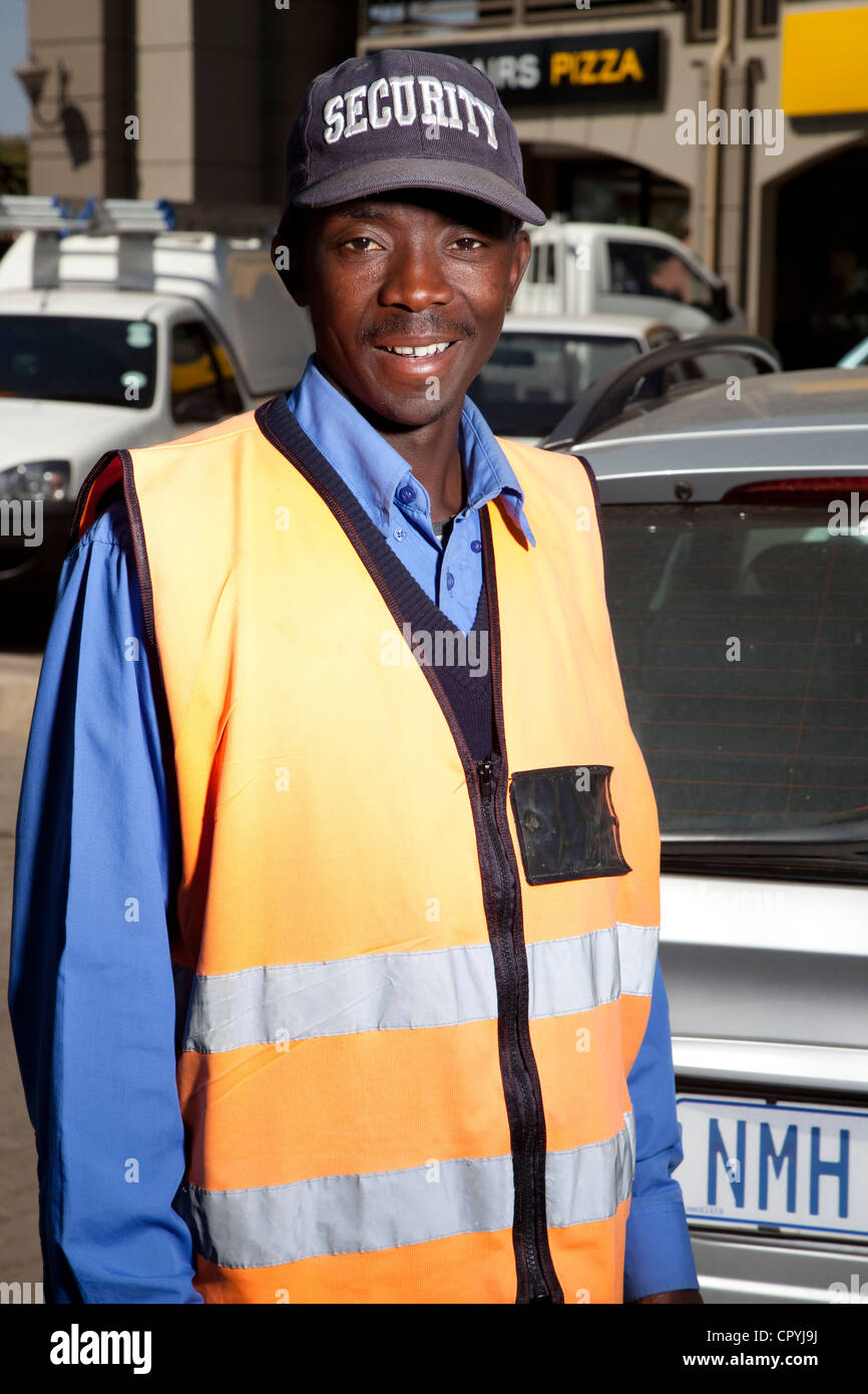 Security guard smiles at camera with cars in the background Stock Photo ...