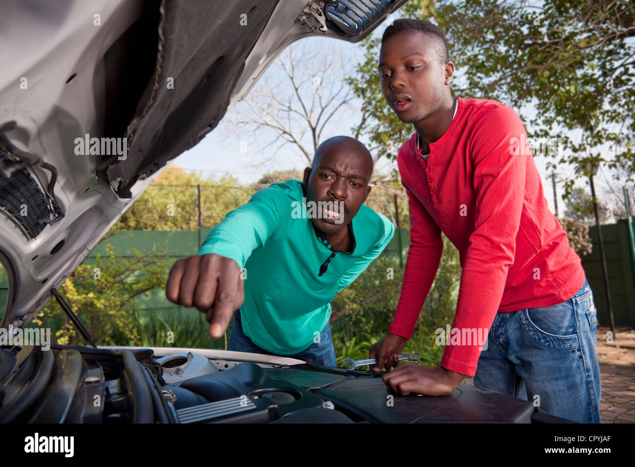 Two African men working on a car engine Stock Photo - Alamy