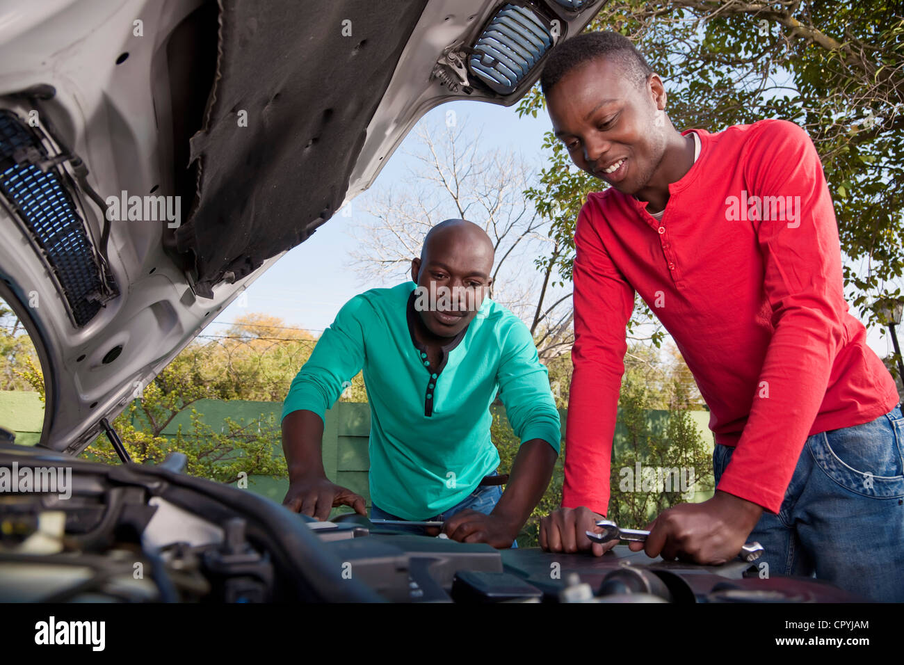 Two African men working on a car engine Stock Photo - Alamy