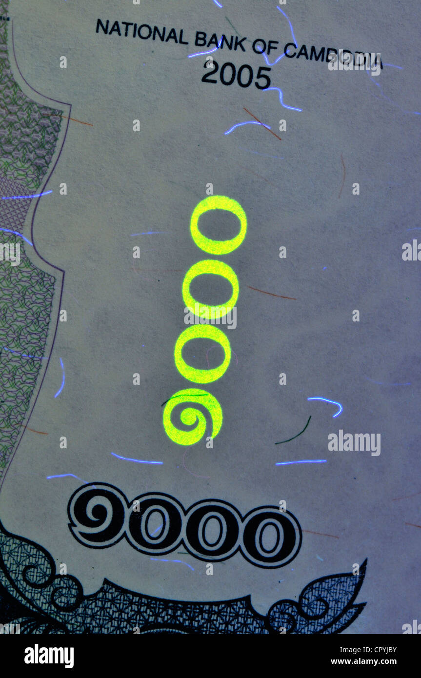 Banknote in ultraviolet light showing otherwise invisible security ...
