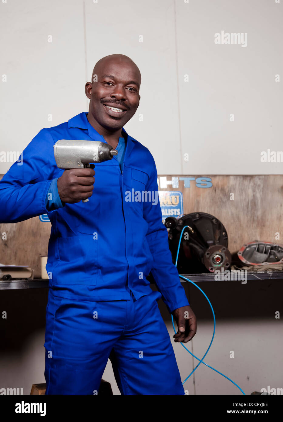 African Mechanic standing in a workshop, smiling at the camera Stock ...