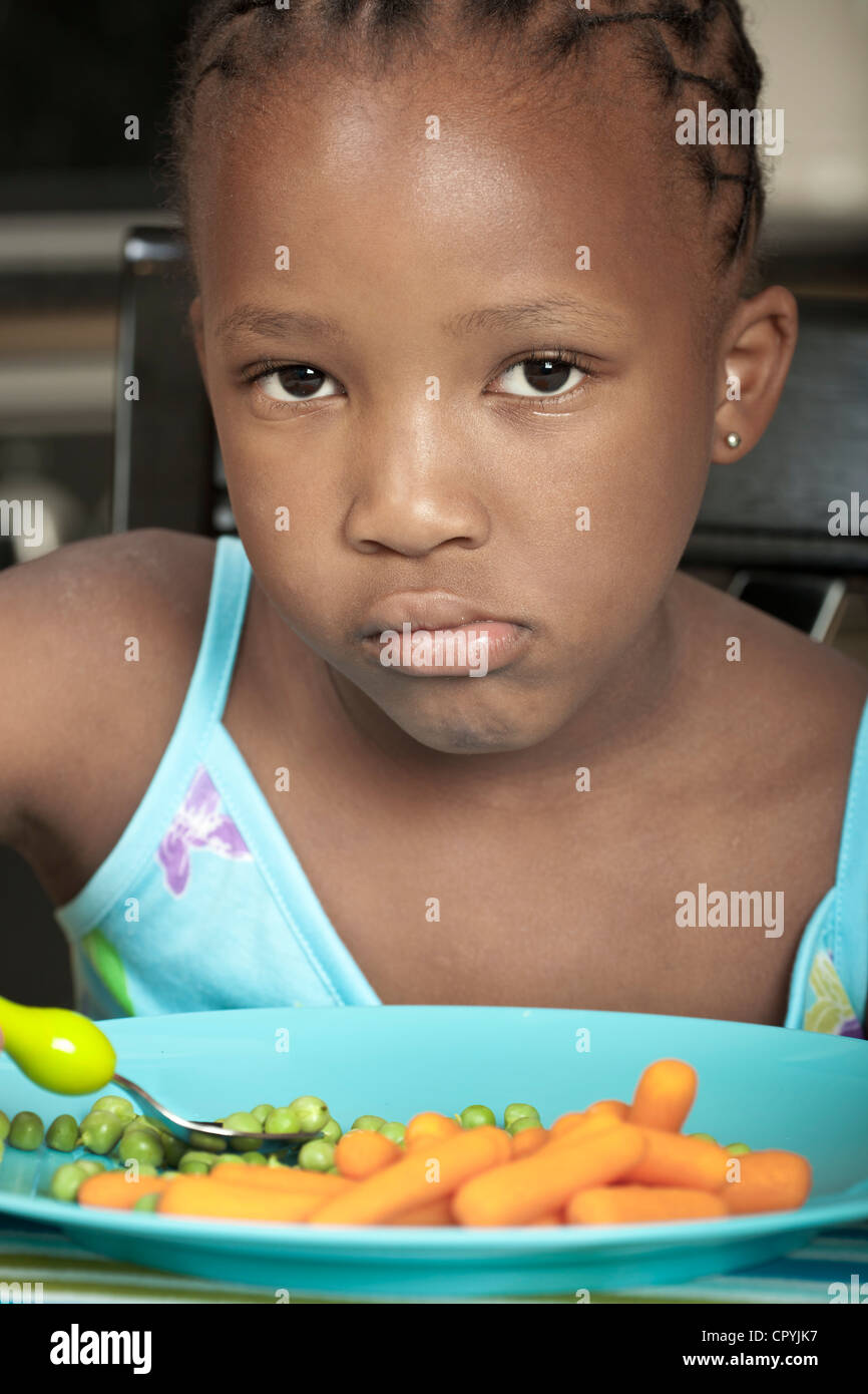 Frowning girl sitting table hi-res stock photography and images - Alamy