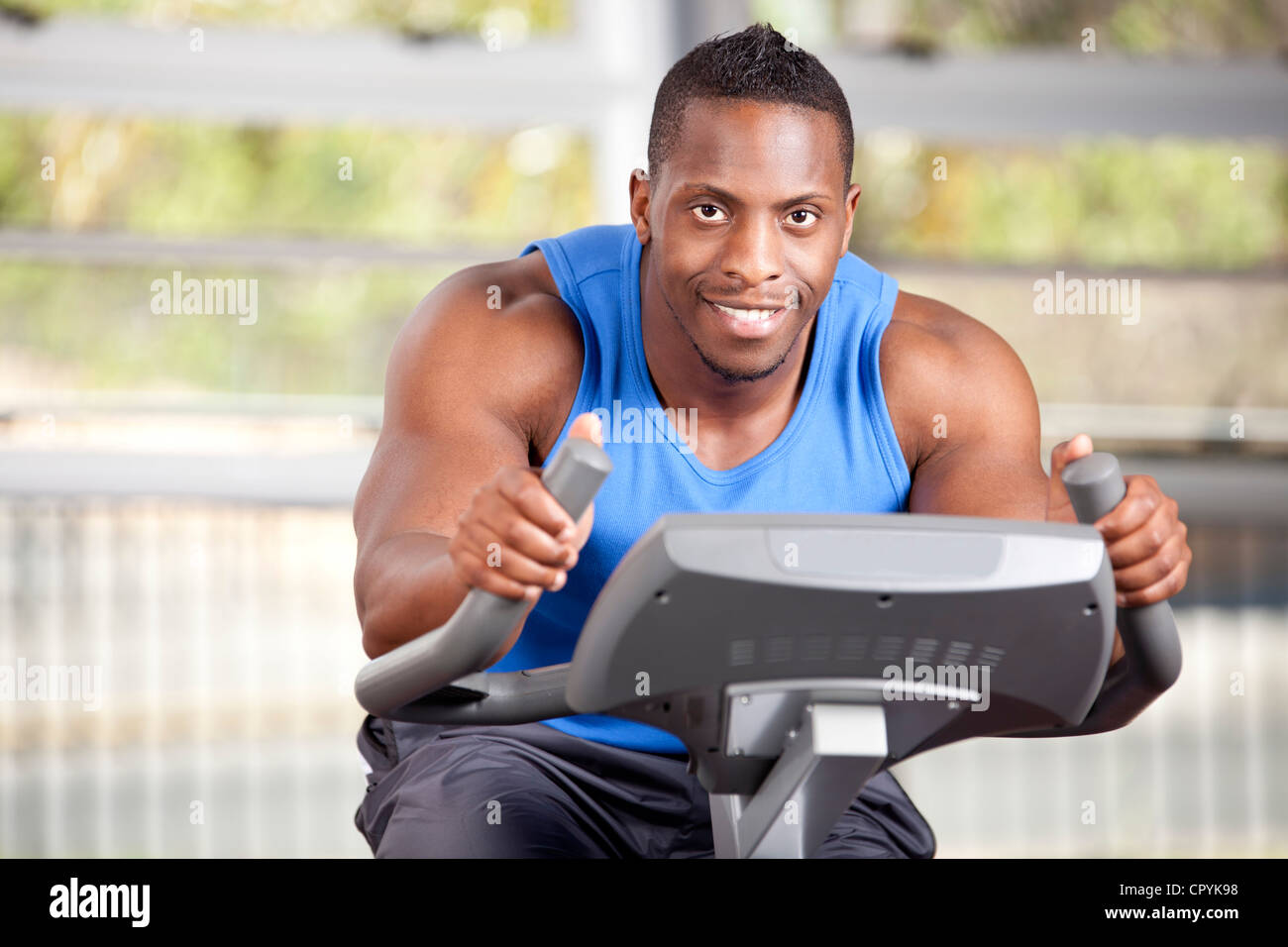 Young black male on a cycling machine in a gym Stock Photo - Alamy