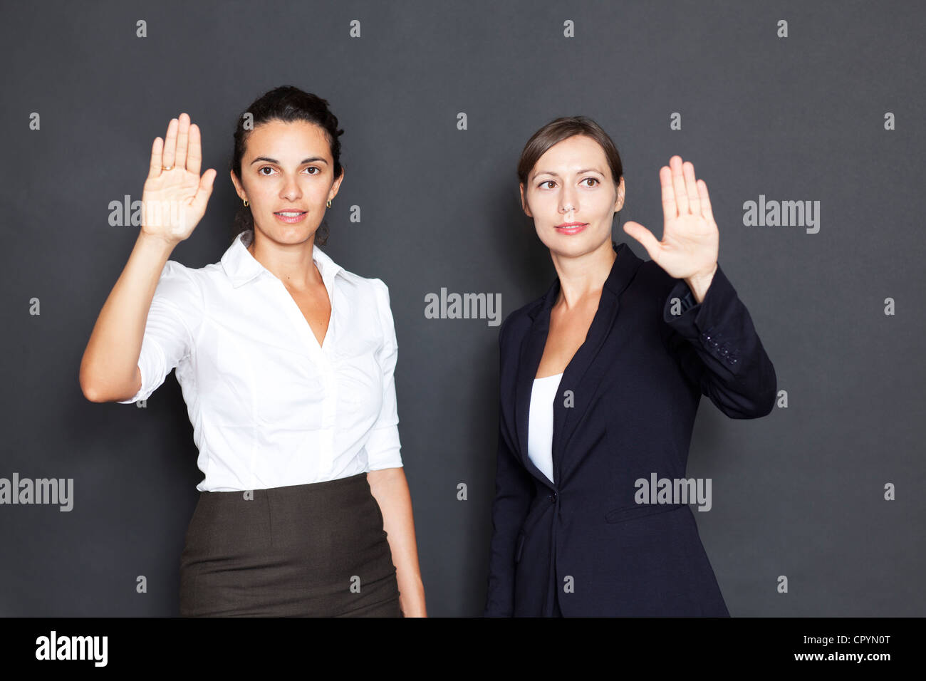 Two women putting hands on virtual screen Stock Photo - Alamy