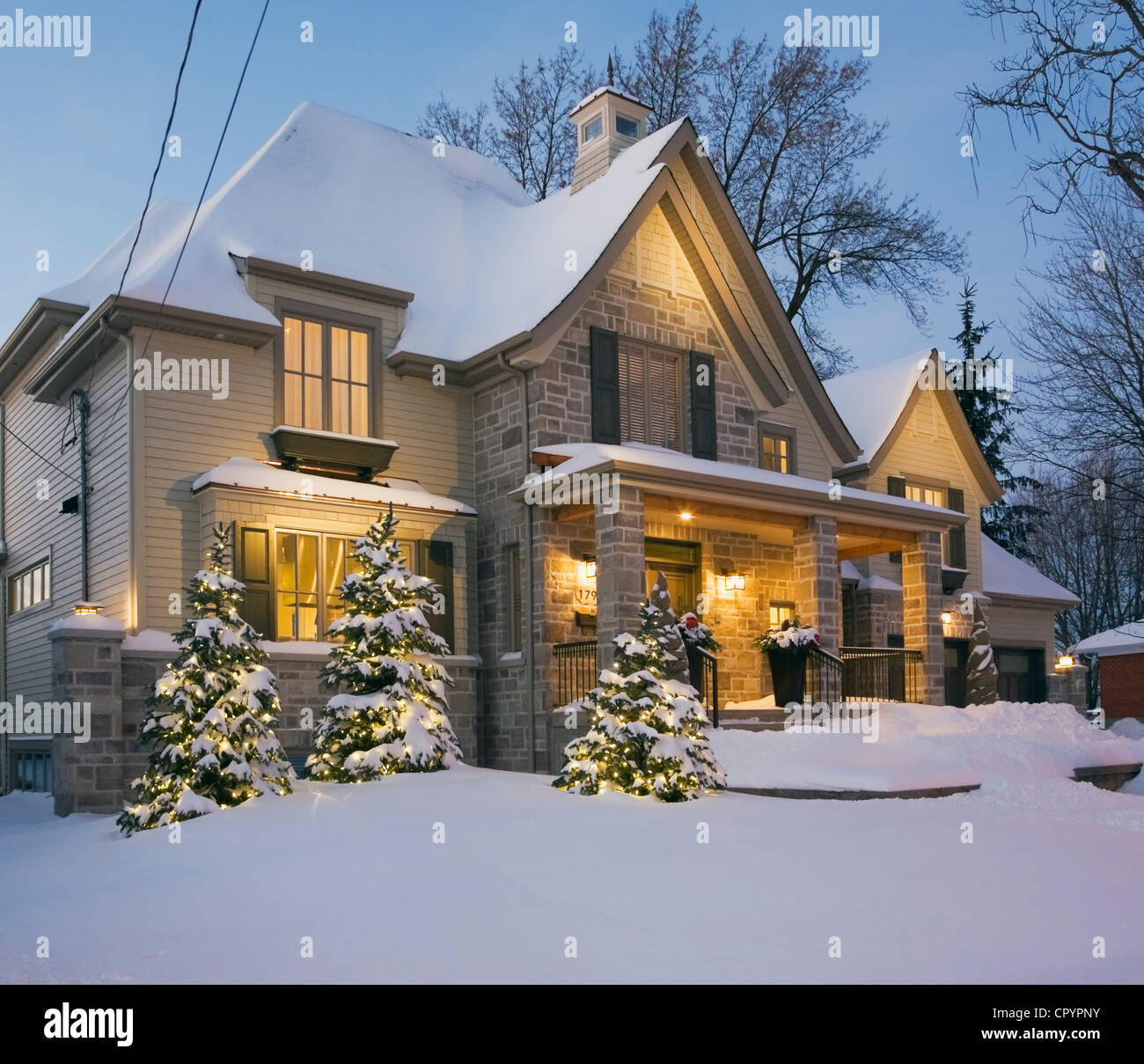 Luxurious residential cottage style home with illuminated evergreen ...