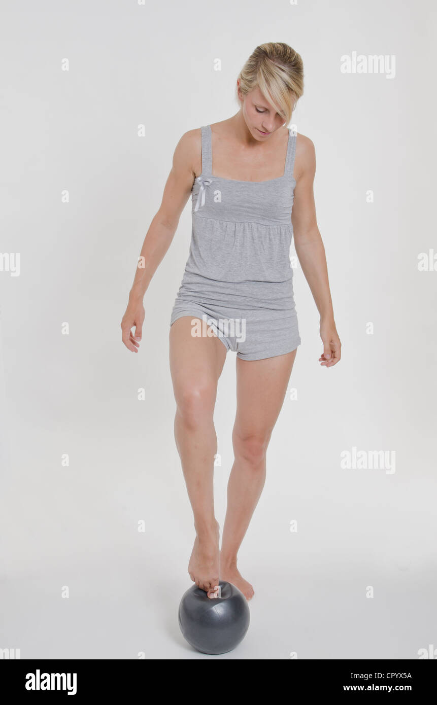 Young woman with an exercise ball under her foot Stock Photo - Alamy