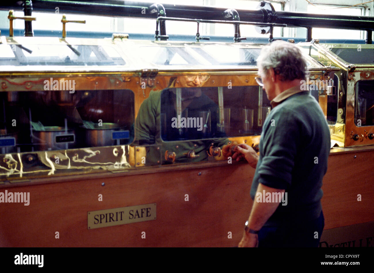 Scottish distillery worker checks hydrometer in spirit safe Stock Photo ...