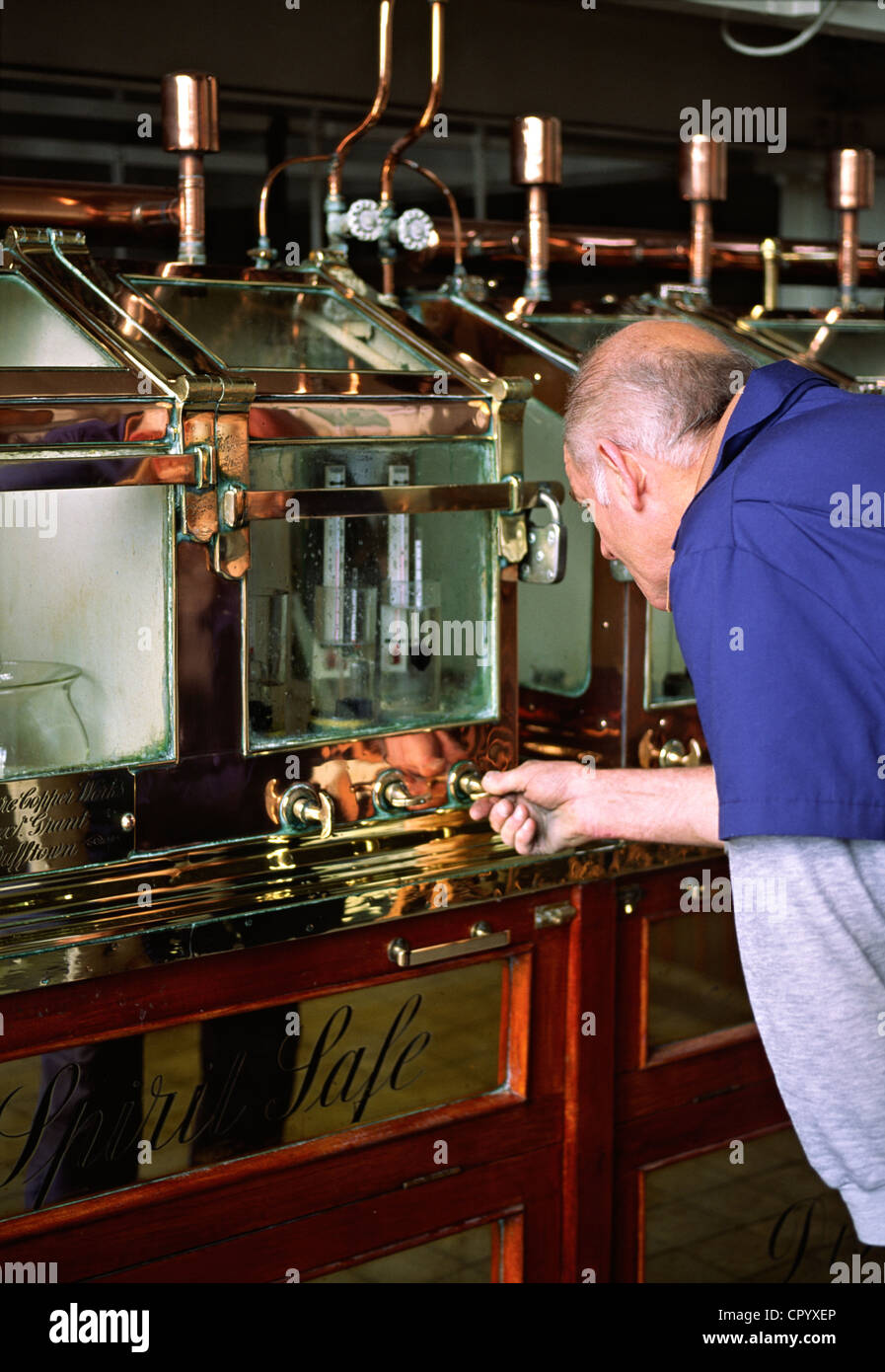Scottish distillery worker checks hydrometer in spirit safe Stock Photo ...