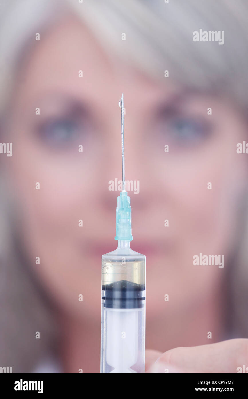 Scientist squeezing drop out of syringe Stock Photo - Alamy