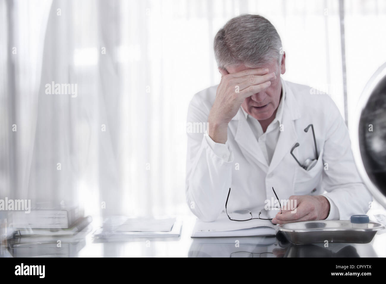 Tired professional rubbing head working hi-res stock photography and ...