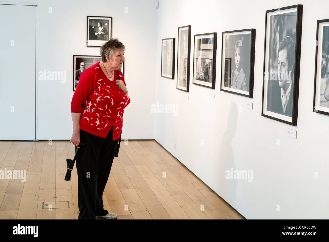 A woman at an exhibition admiring the work. Original photographs by ...