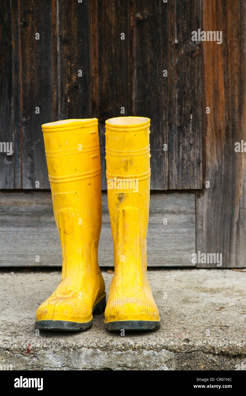 Pair of yellow rubber boots in front of door Stock Photo - Alamy
