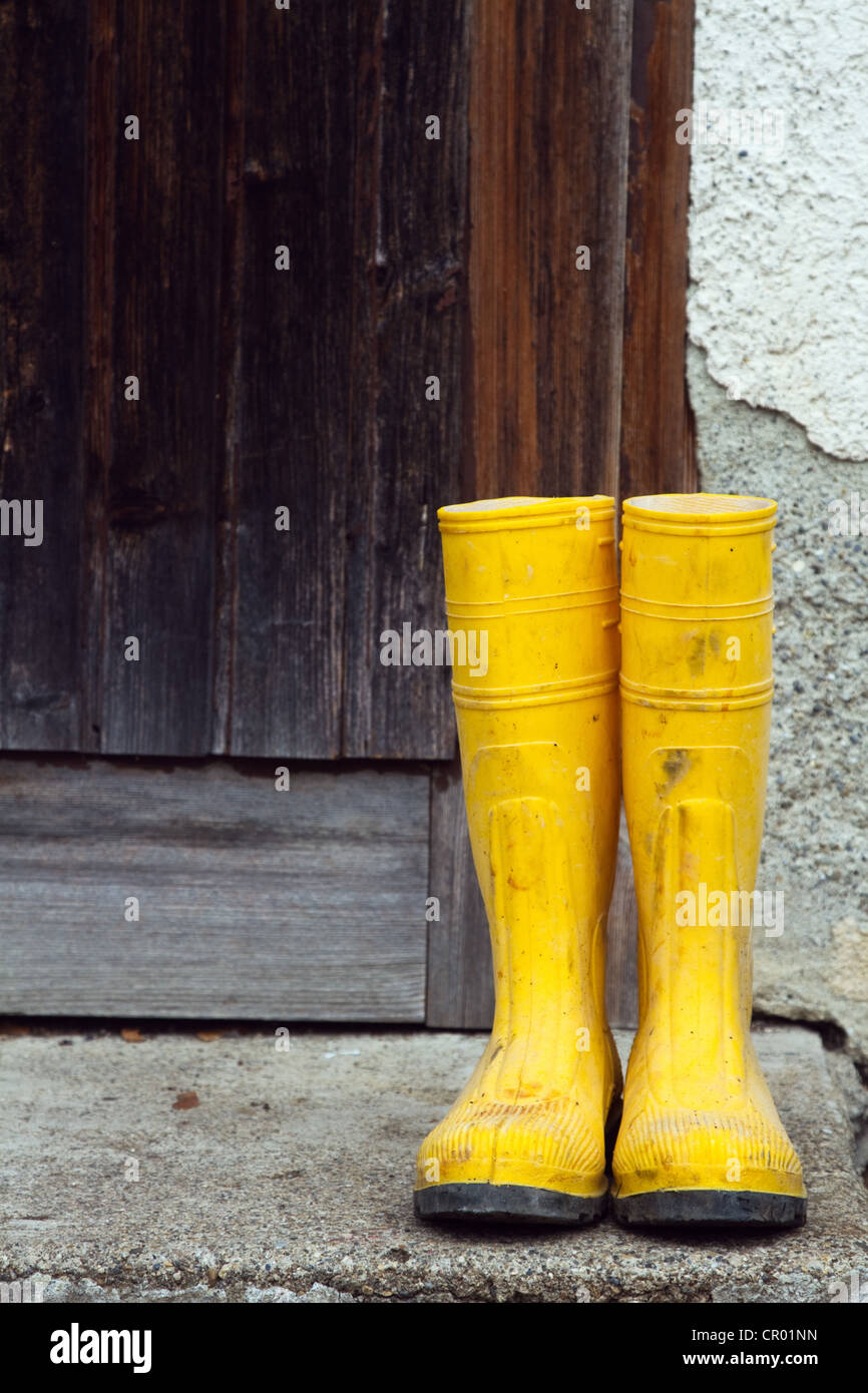Pair of yellow rubber boots in front of door Stock Photo - Alamy
