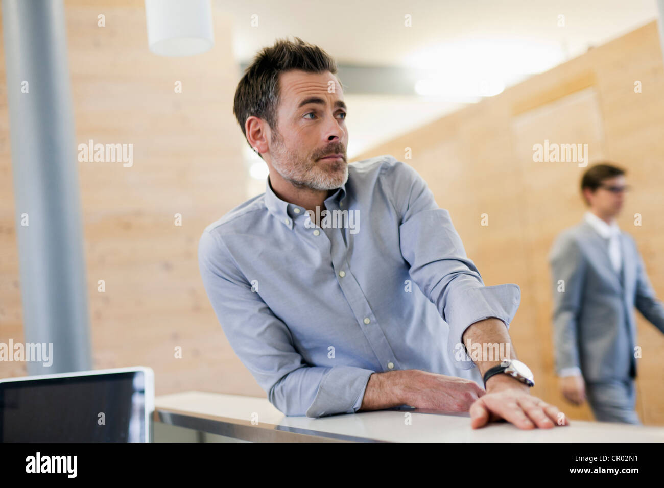 Businessman on counter in office Stock Photo - Alamy