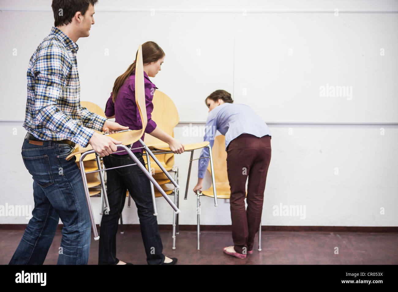 Business people stacking chairs Stock Photo - Alamy