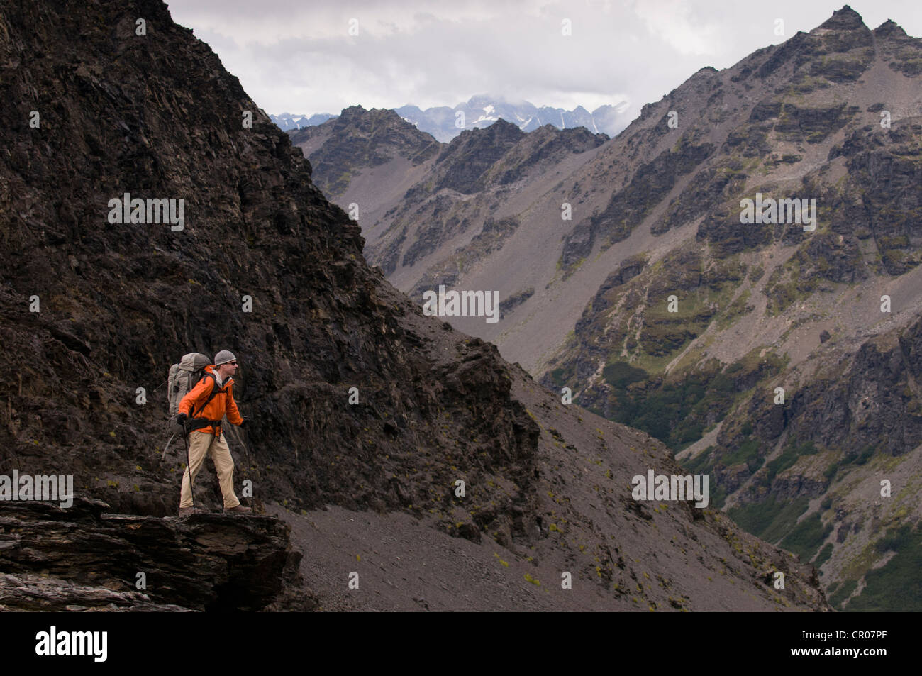 Hiker walking with sticks in rocky hills Stock Photo - Alamy