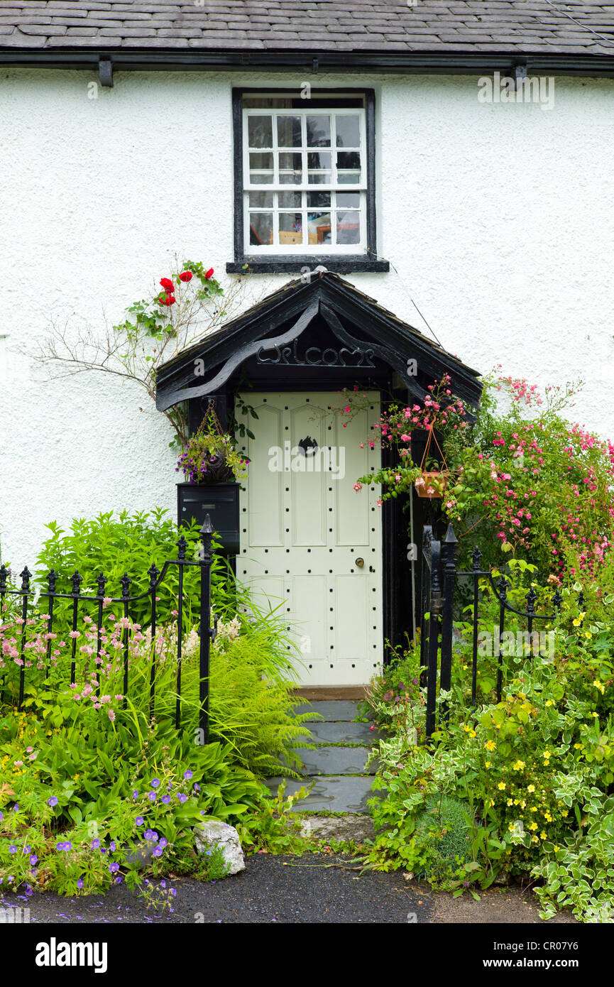 Quaint lakeland cottage with studded front door and Welcome sign, at ...
