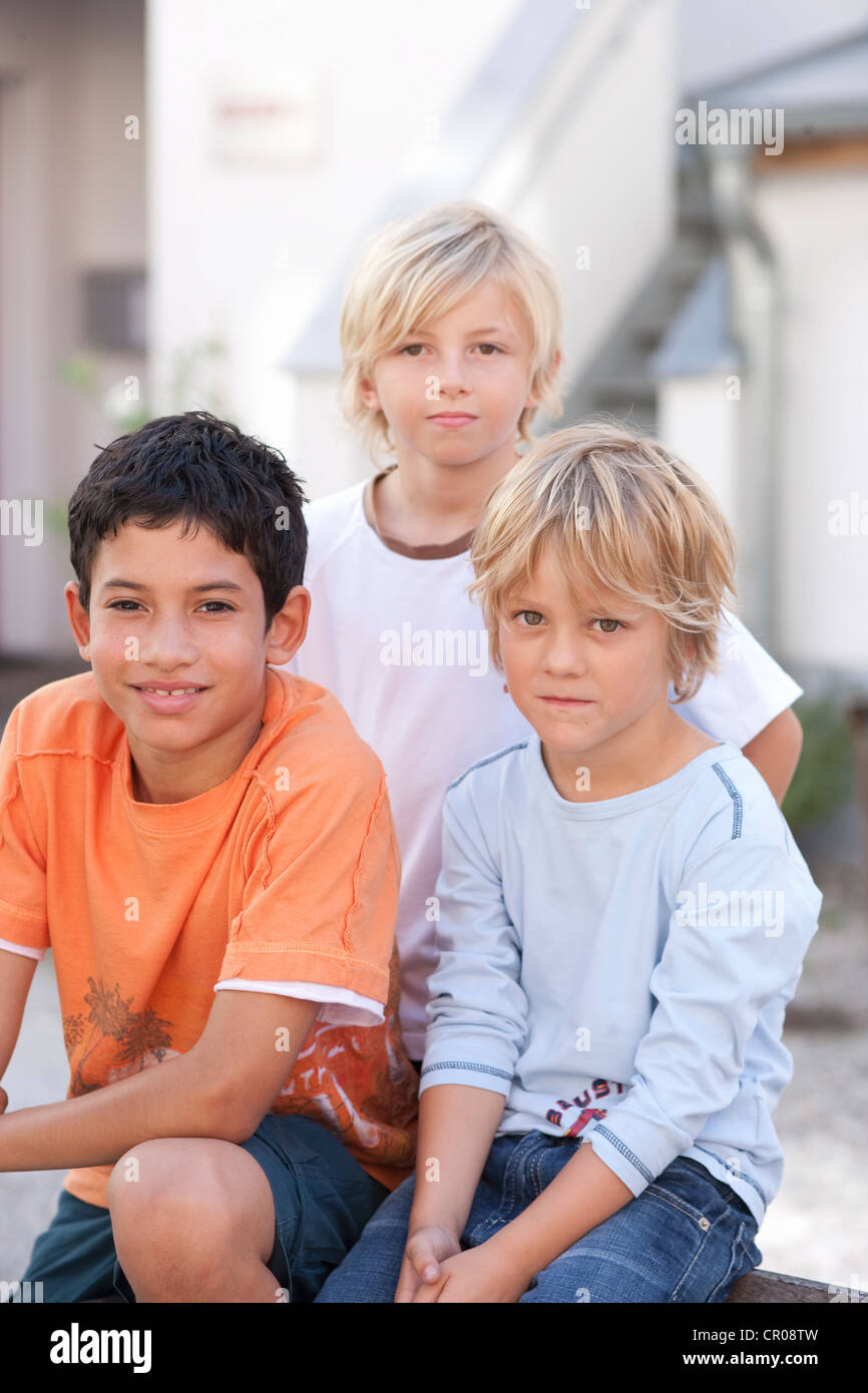Smiling boys sitting together outdoors Stock Photo - Alamy