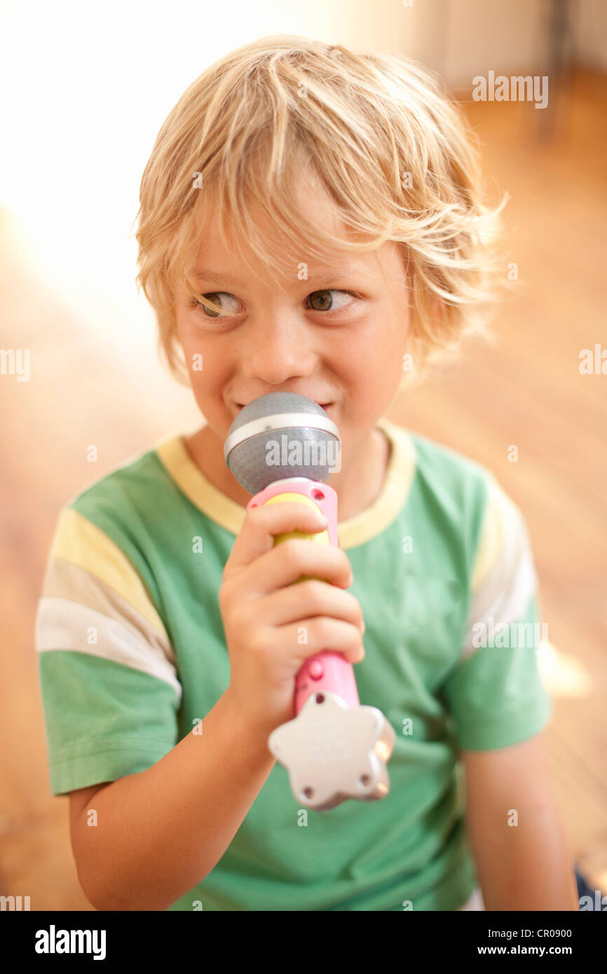 Smiling boy playing with toy microphone Stock Photo - Alamy