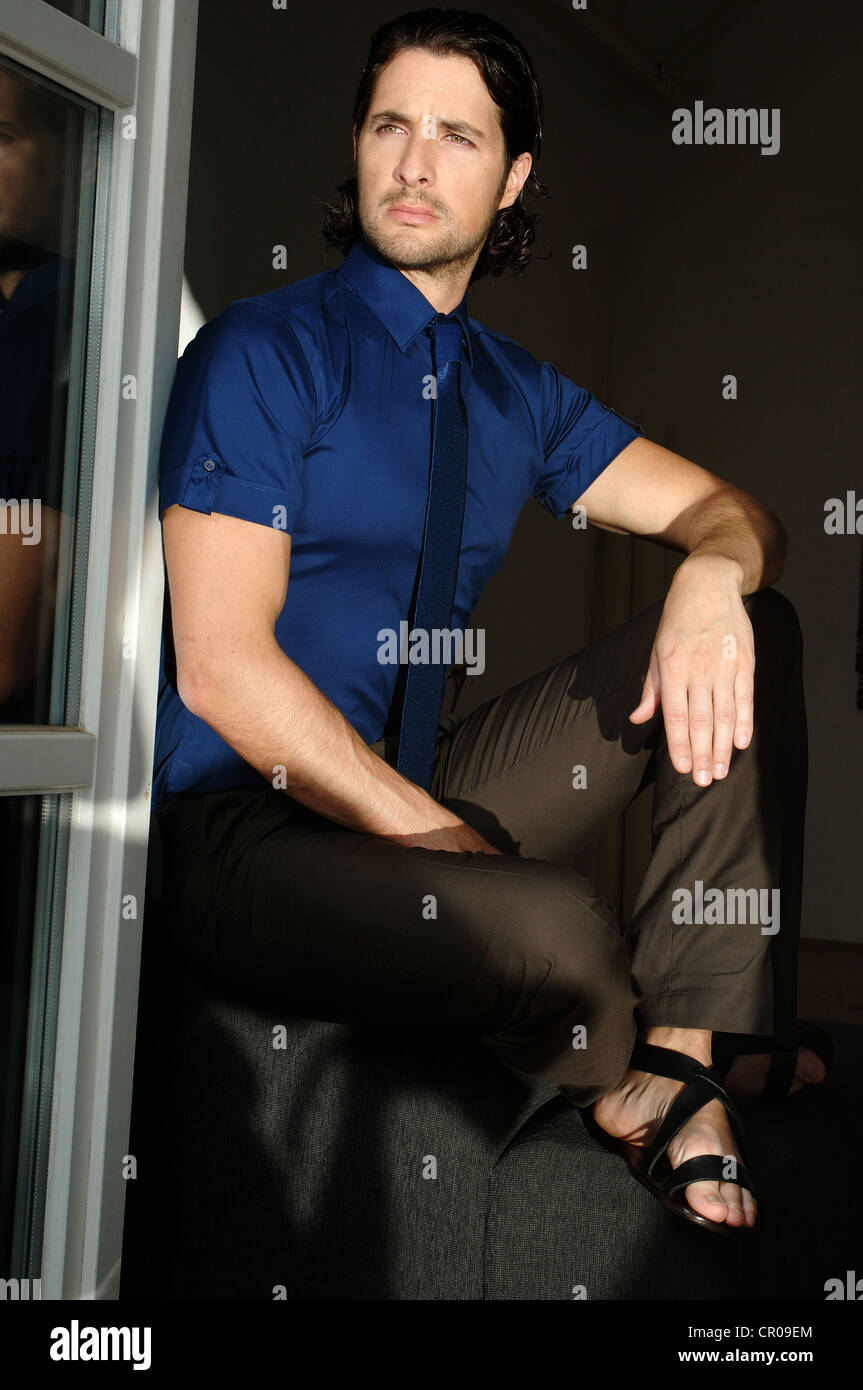 Man sitting by a window, fashion shoot Stock Photo - Alamy