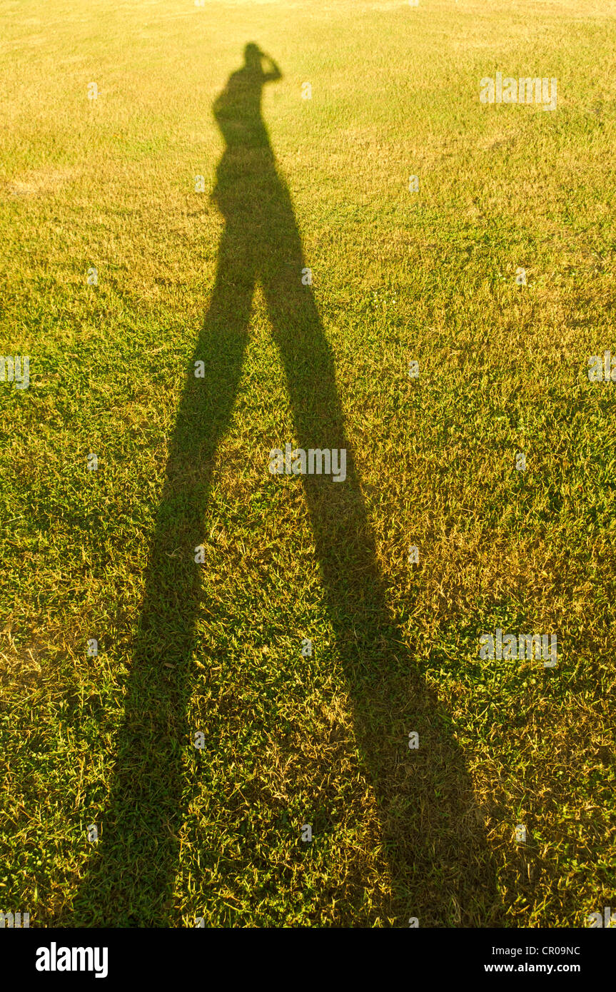 long shadow of man on grass field, for conceptual usage Stock Photo - Alamy
