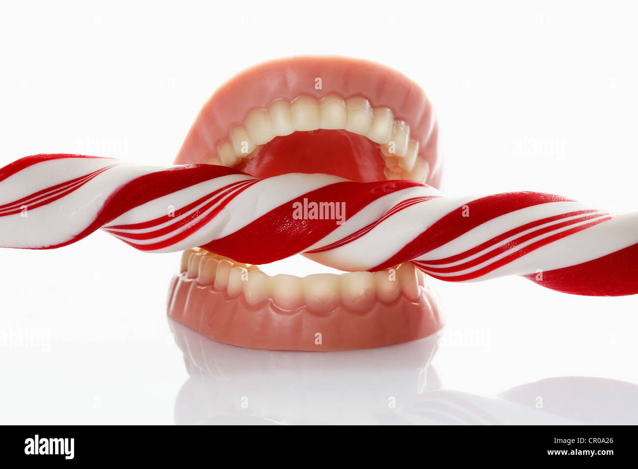 Candy cane and dentures, symbolic image for caries Stock Photo - Alamy