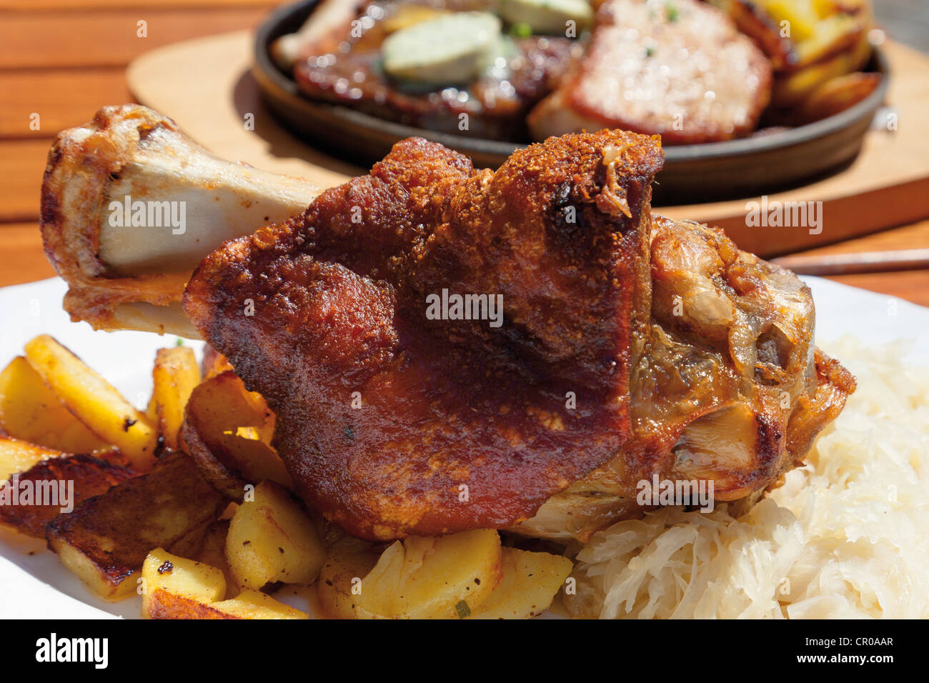 Grilled pork knuckle with fried potatoes and sauerkraut Stock Photo - Alamy