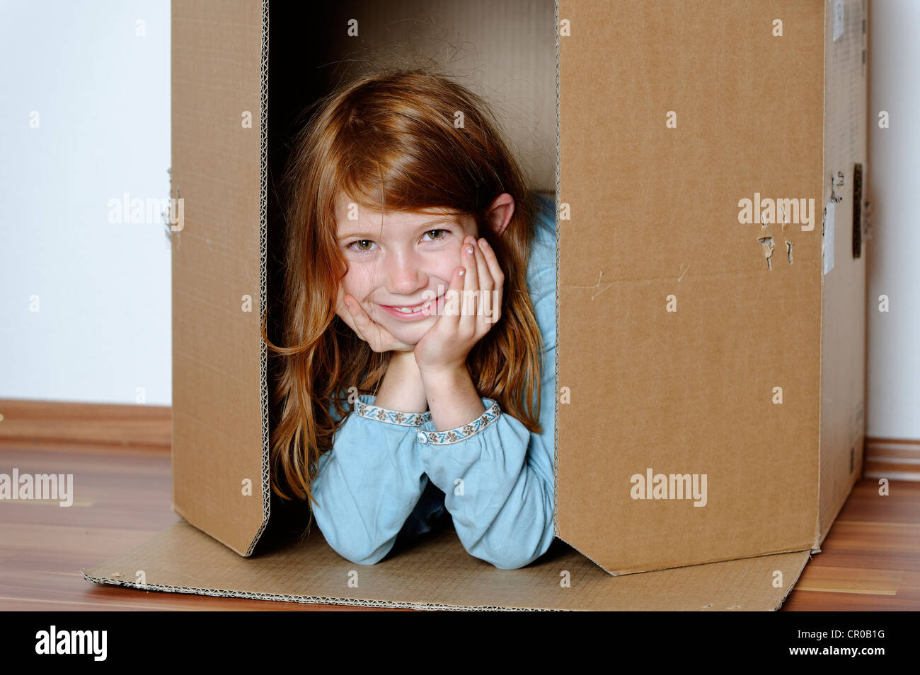 Girl playing in an empty cardboard box Stock Photo - Alamy