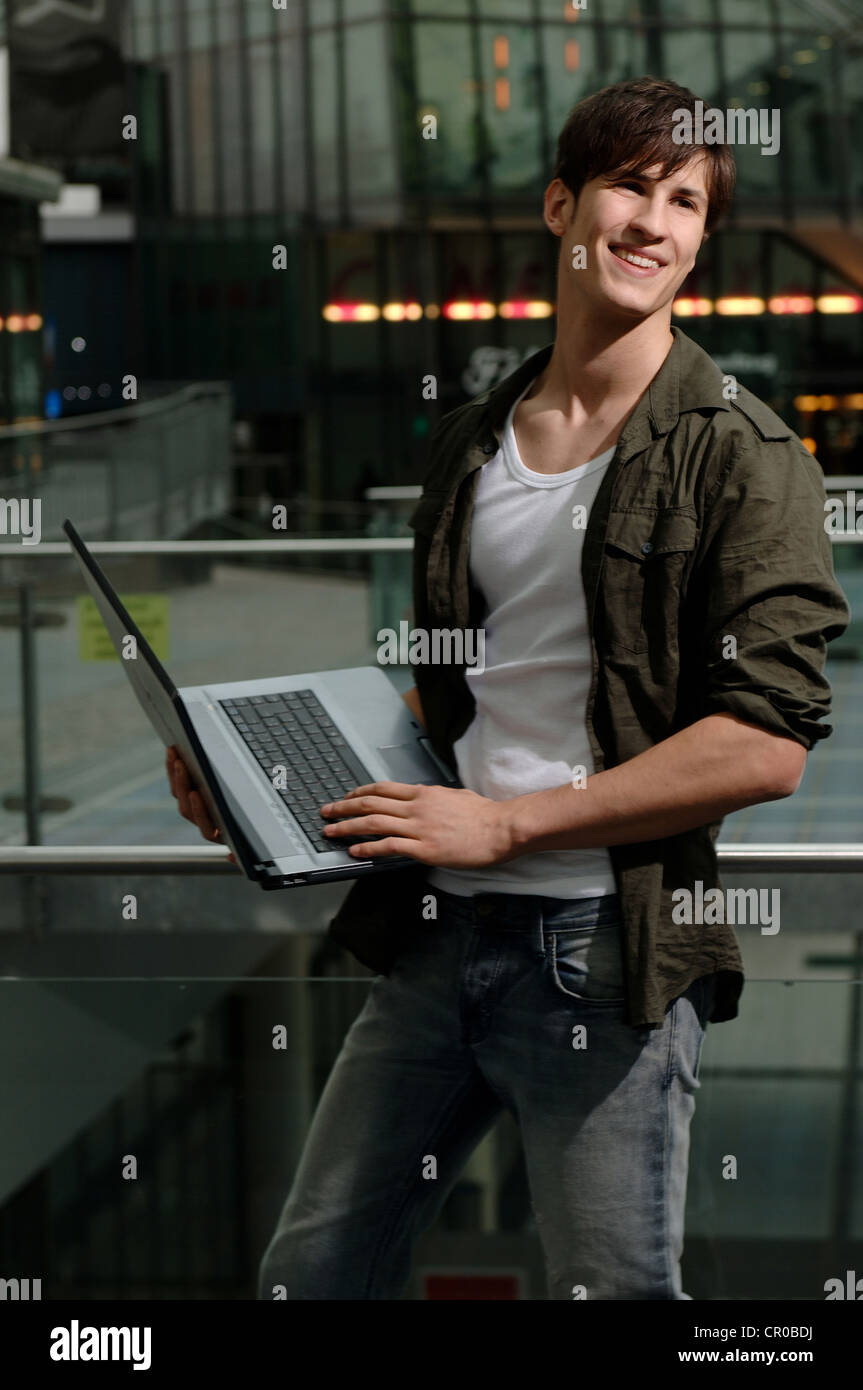 Student holding a laptop computer, smiling Stock Photo - Alamy