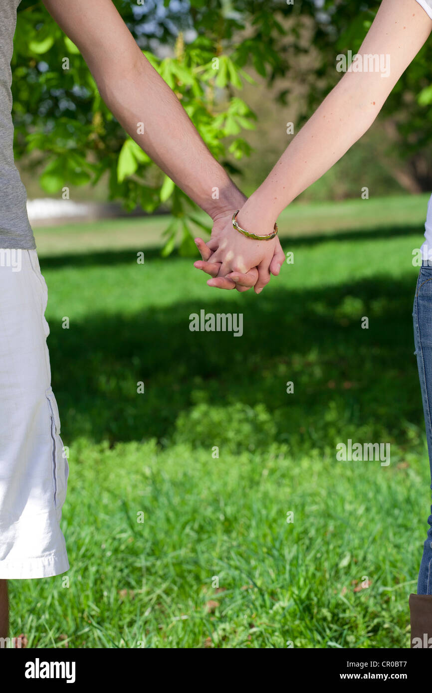 Young couple holding hands in a park in spring Stock Photo - Alamy