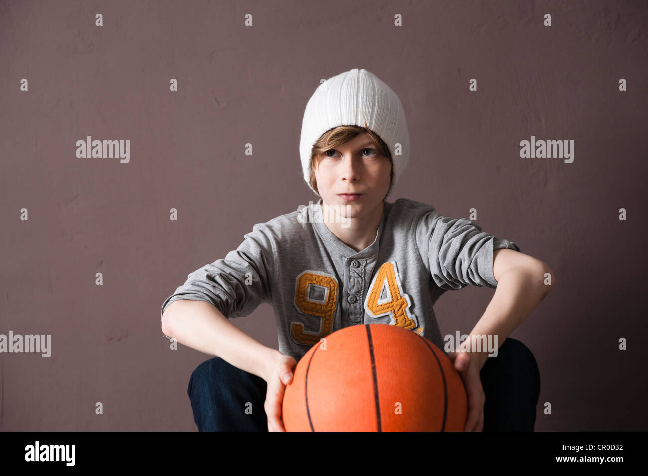 Cool boy wearing a cap and holding a basketball Stock Photo - Alamy